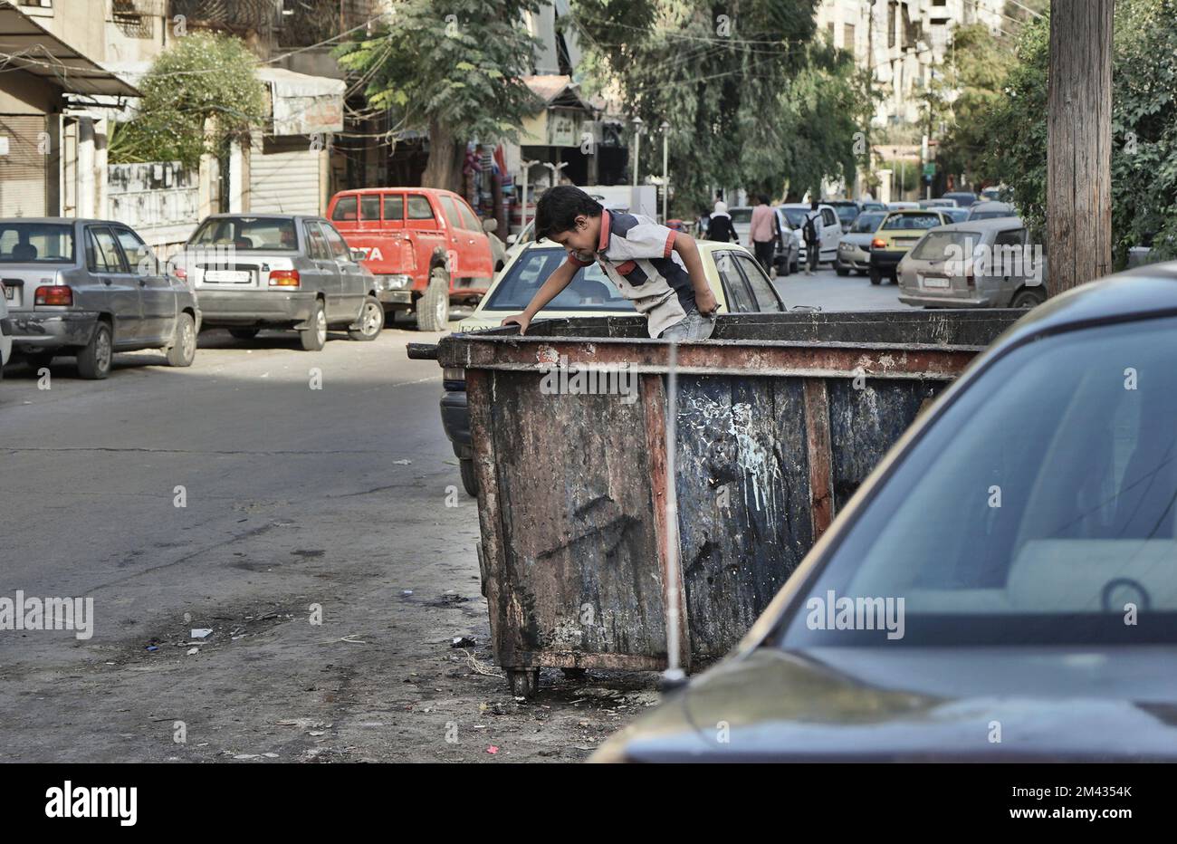 Aleppo, Syria, a kid collecting food from the trash bin Stock Photo - Alamy