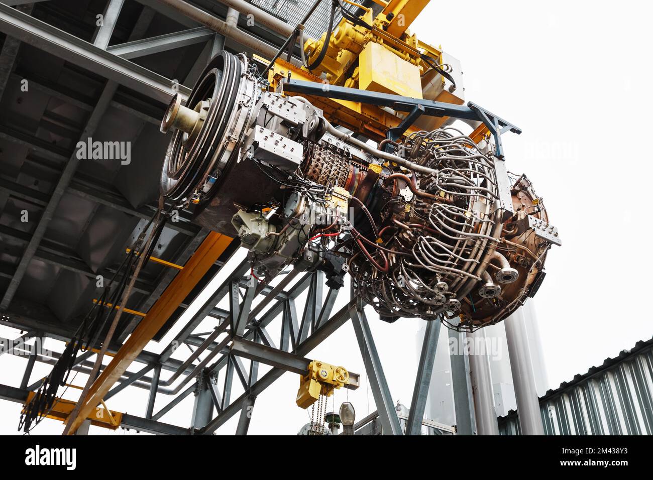 The engine of a gas turbine compressor hangs on a crane during ...