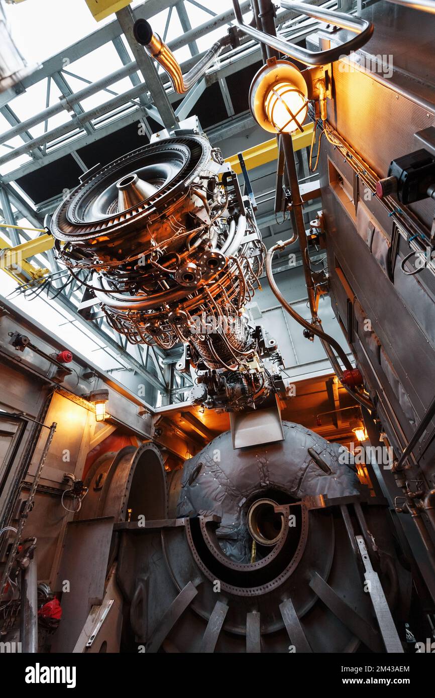 The engine of a gas turbine compressor hangs on a crane during ...
