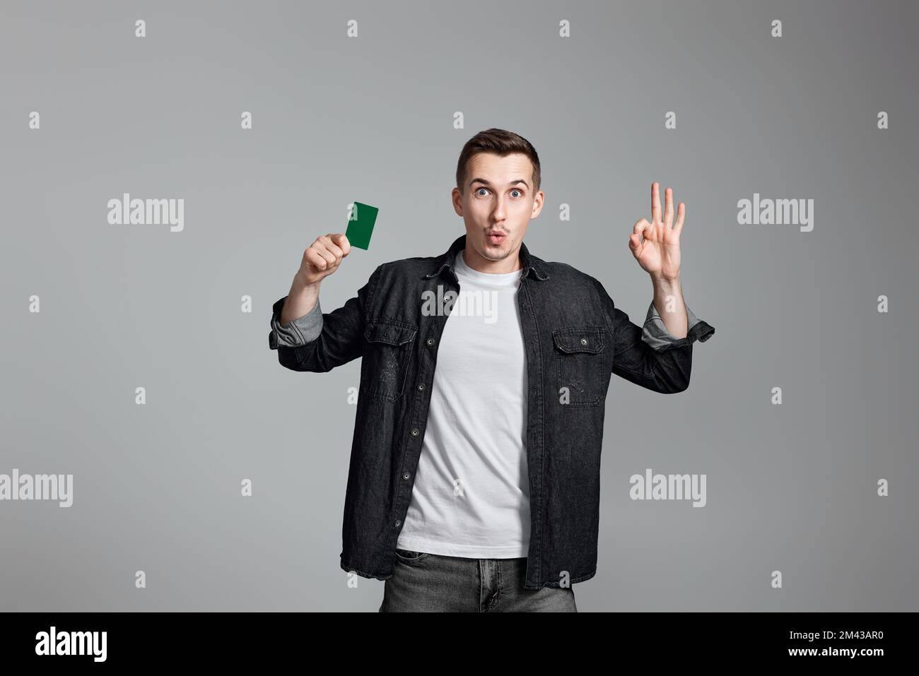 young man holding a credit card and doing okay gesture Stock Photo - Alamy