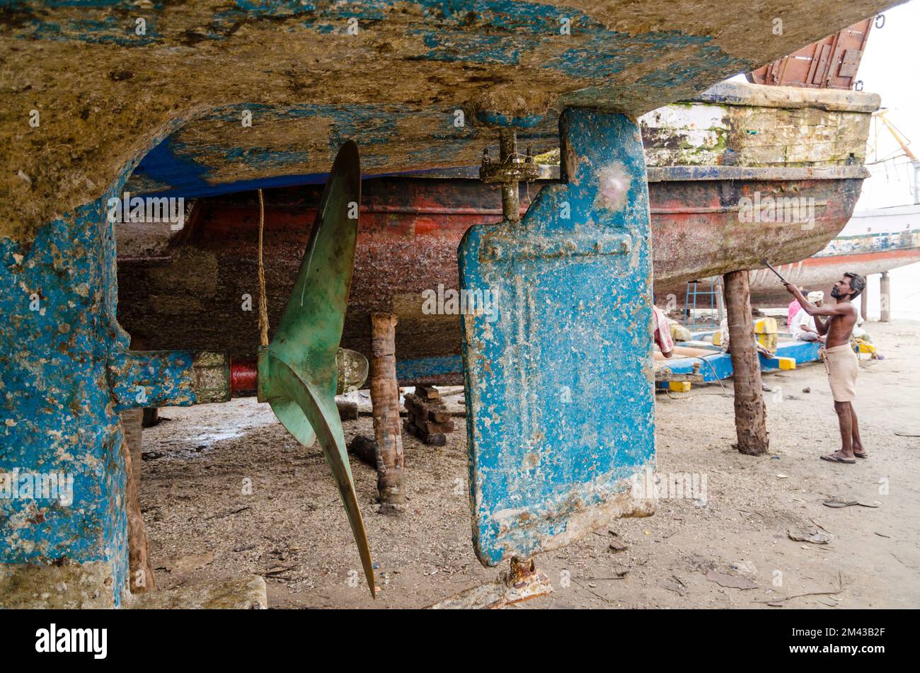 Fisherman cleaning his boot from mussels in the harbour Stock Photo - Alamy