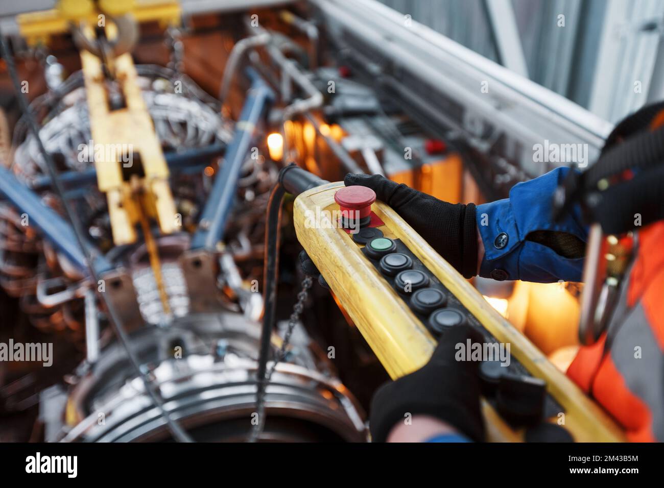 The engine of a gas turbine compressor hangs on a crane during ...