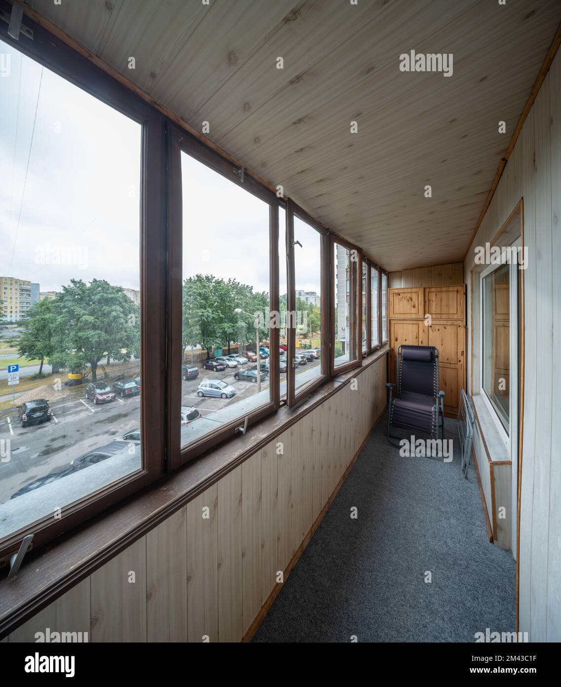 Chair on balcony of modern apartment. View to parking with cars Stock ...