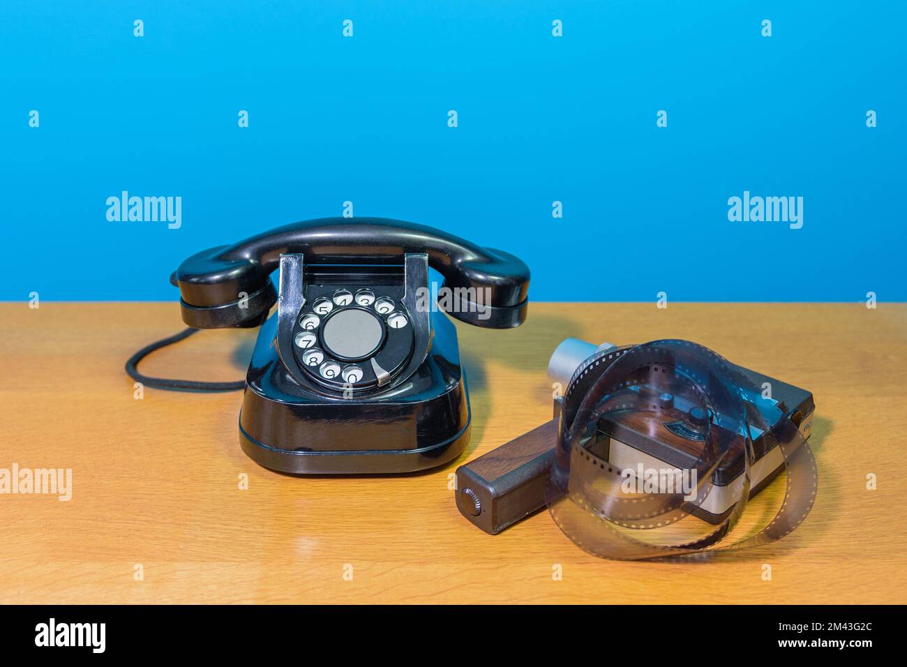 Old movie camera, film and old phone on the table. retro scene. light ...