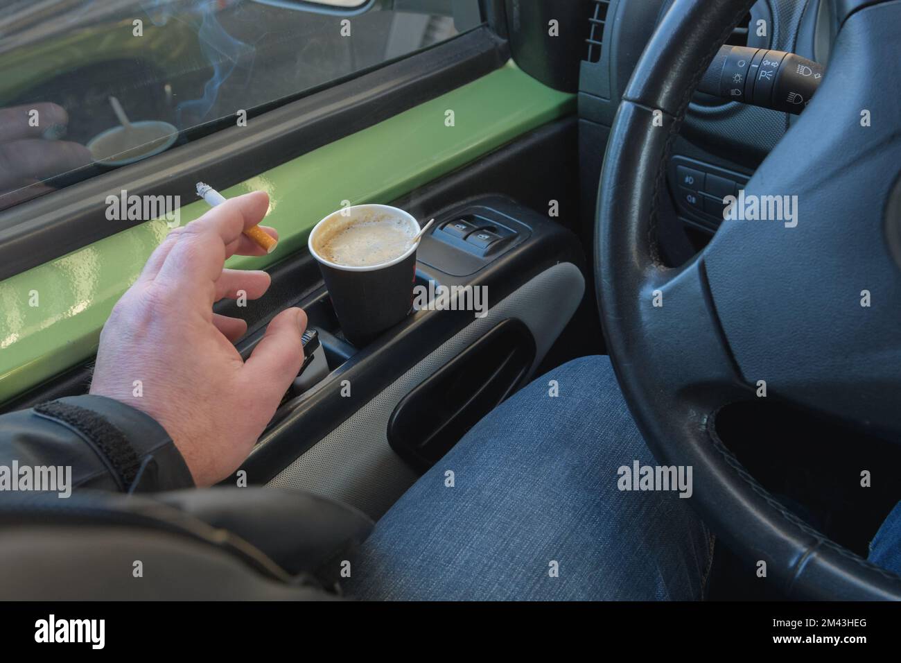 Smoking while driving a car while driving. Cigarette in hand. Paper ...