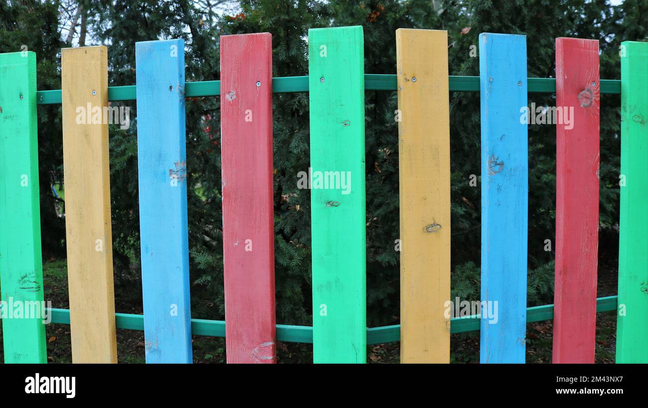 colorful painted wooden texture plank fence in a park or garden ...