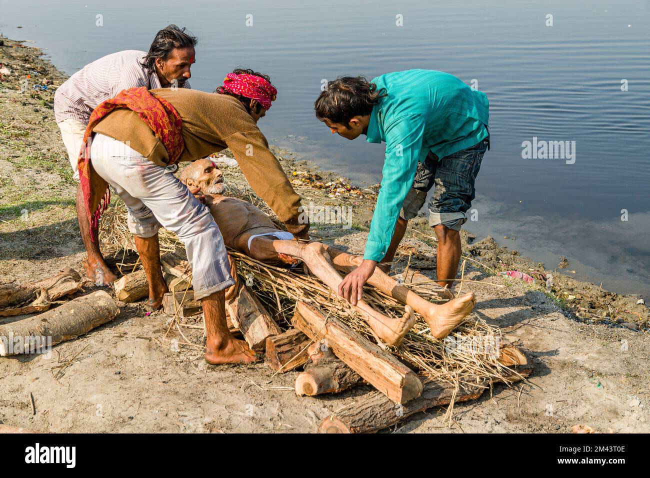 Putting a death body on firewood on the banks of river Yamuna as part ...