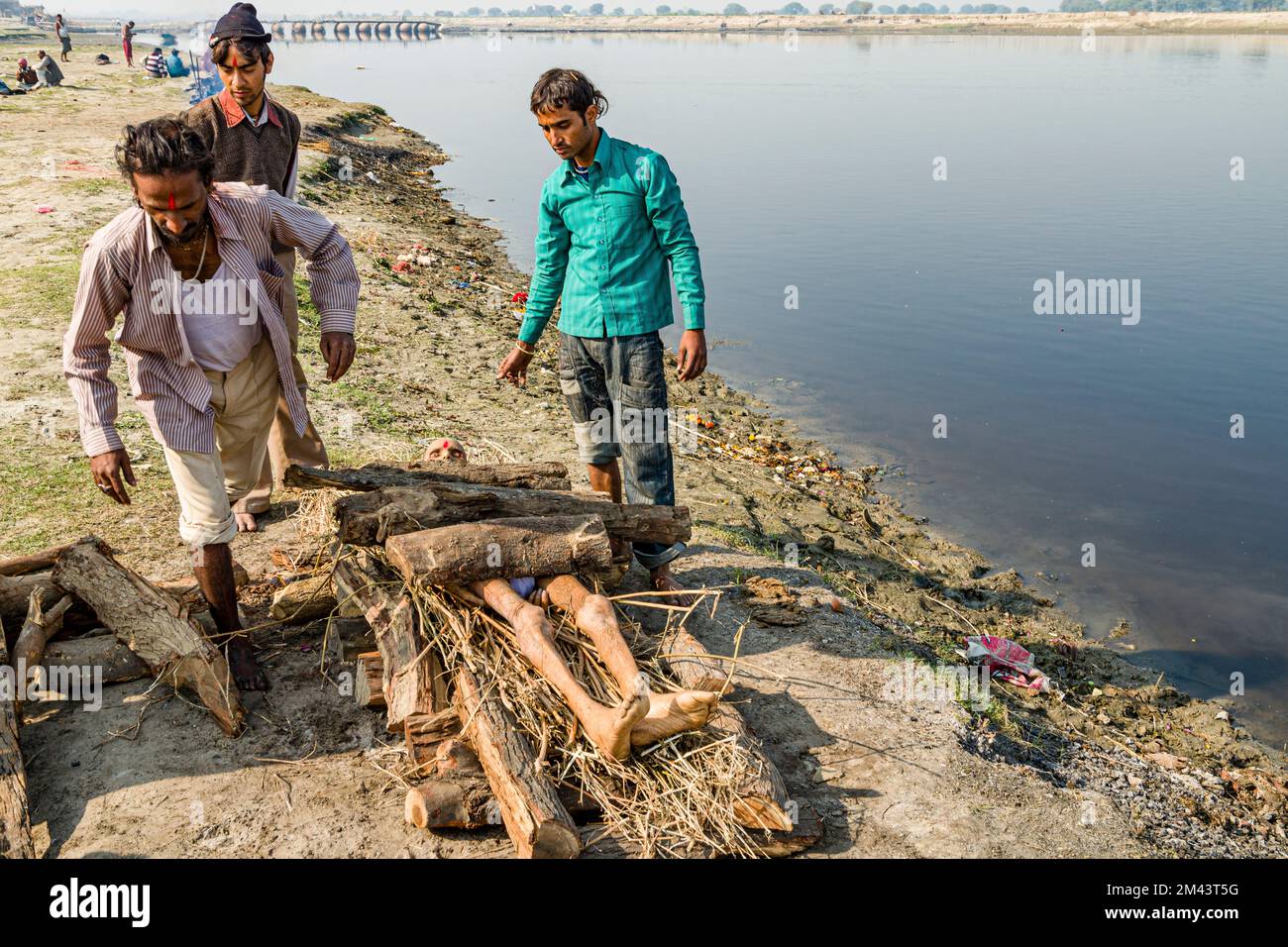Putting a death body on firewood on the banks of river Yamuna as part ...