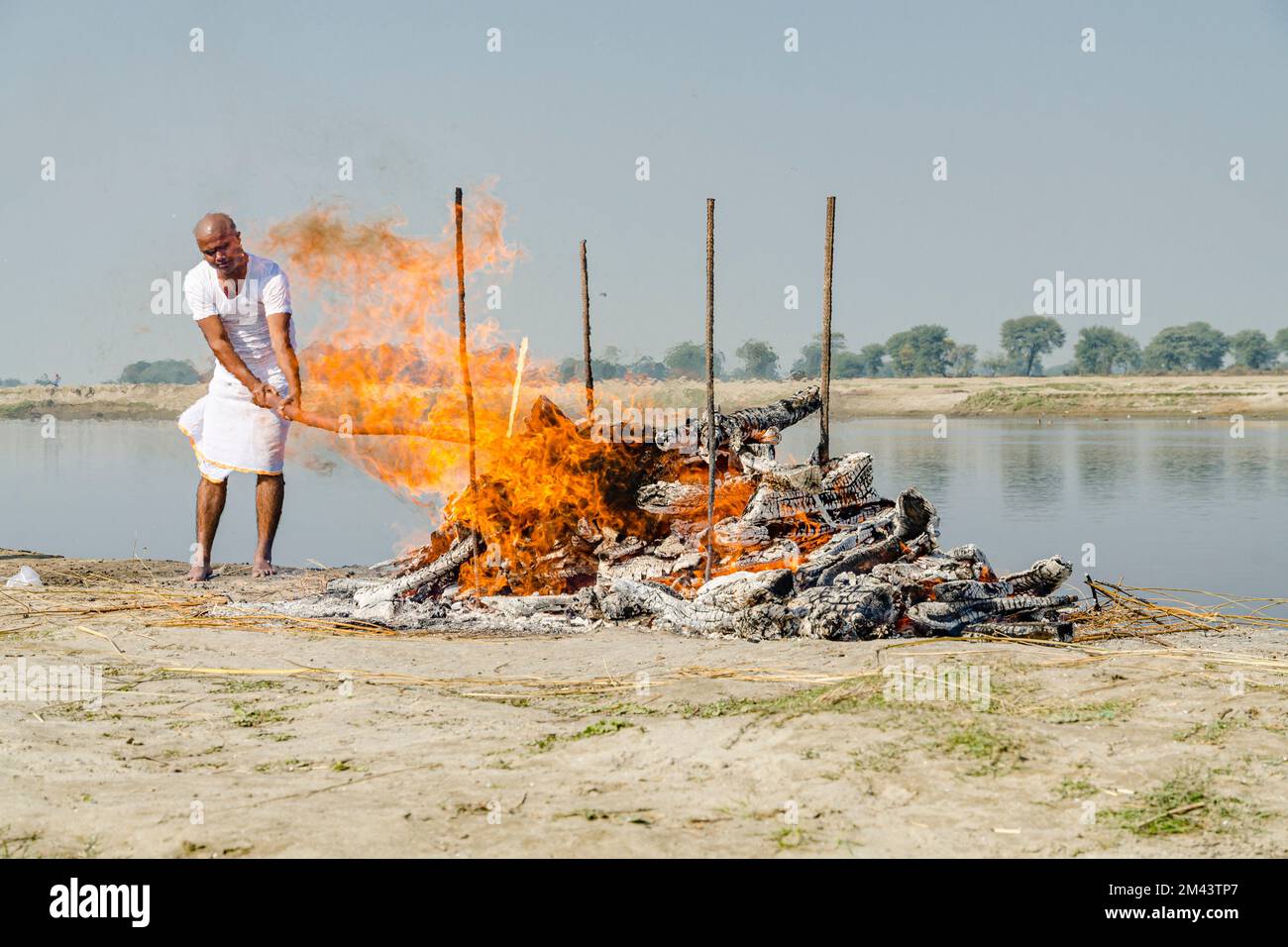 The eldest son maintaining the fire as part of a cremation ceremony ...