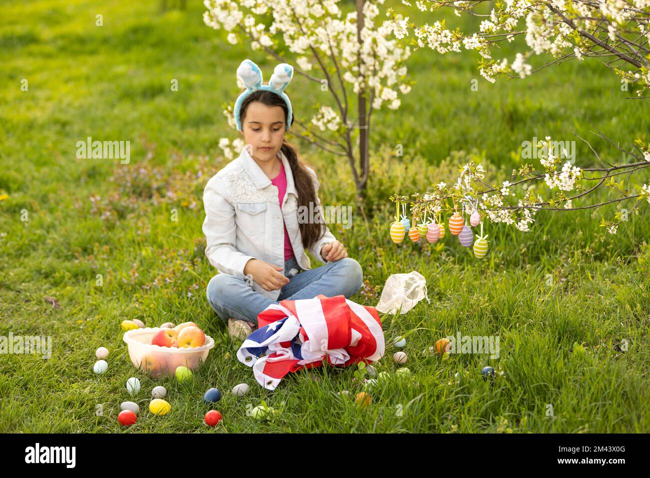 Girl kid in rabbit bunny ears on head with colored eggs and american ...