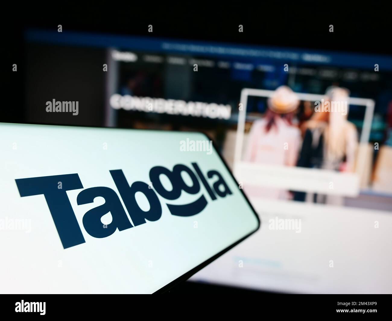 Cellphone with logo of American advertising company Taboola Inc. on screen in front of business ...