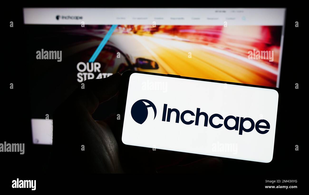 Person holding cellphone with logo of British automotive company ...