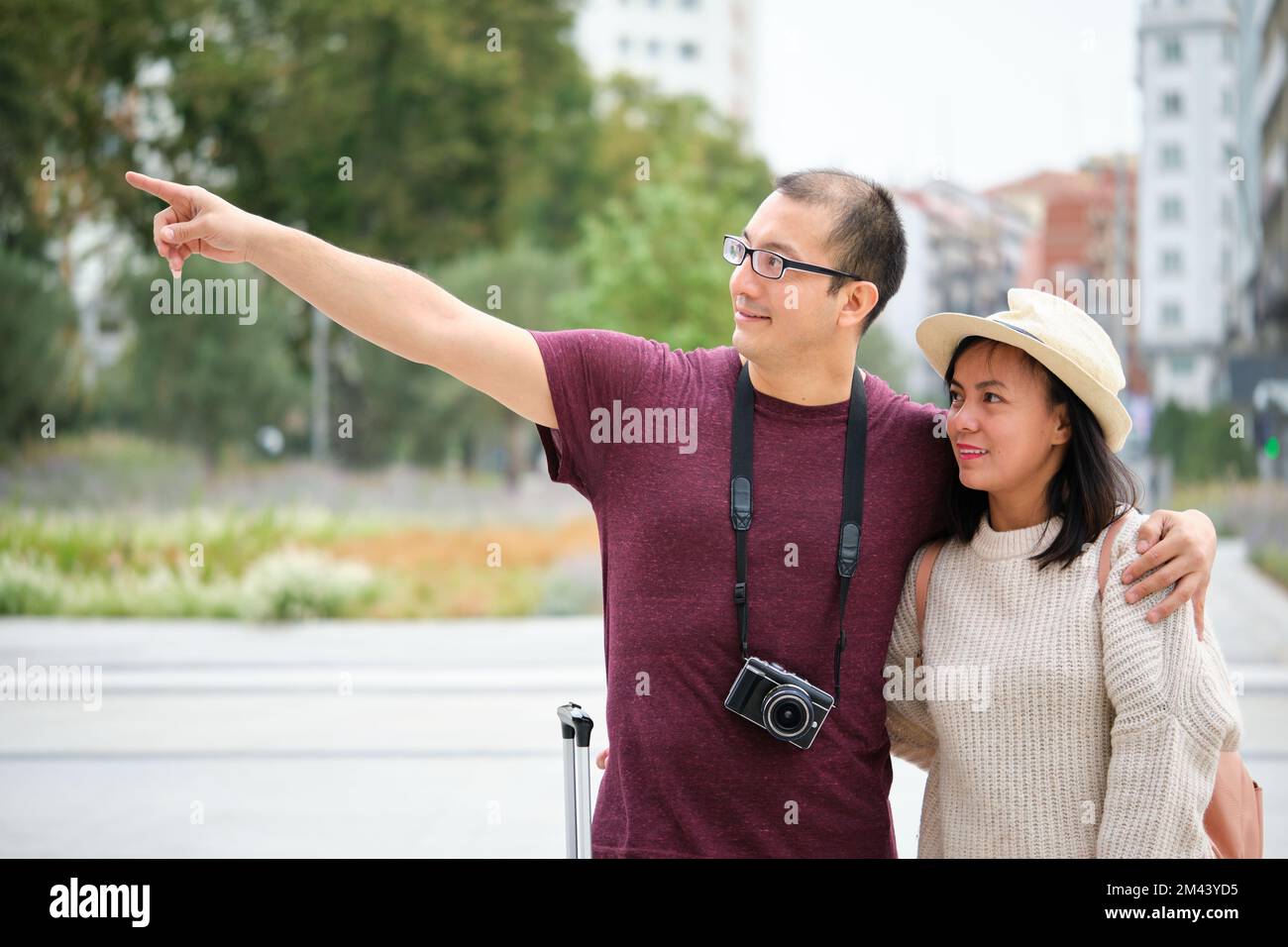 Multiracial couple of tourists exploring the city together and pointing ...