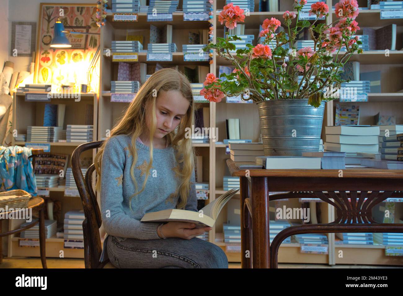 young girl riding book in bookstore Stock Photo - Alamy