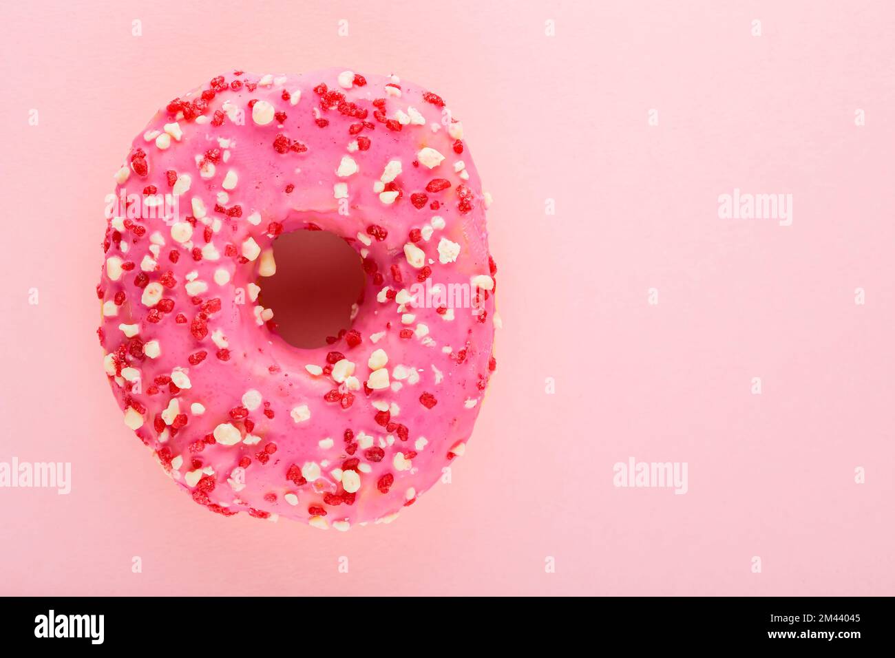 Pink donut with sprinkles on pink pastel background. One sweet pink ...