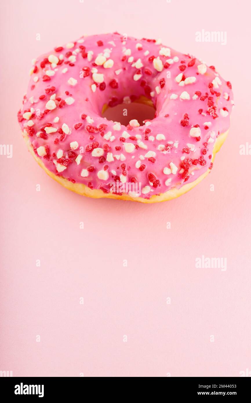 Pink donut with sprinkles on pink pastel background. One sweet pink ...