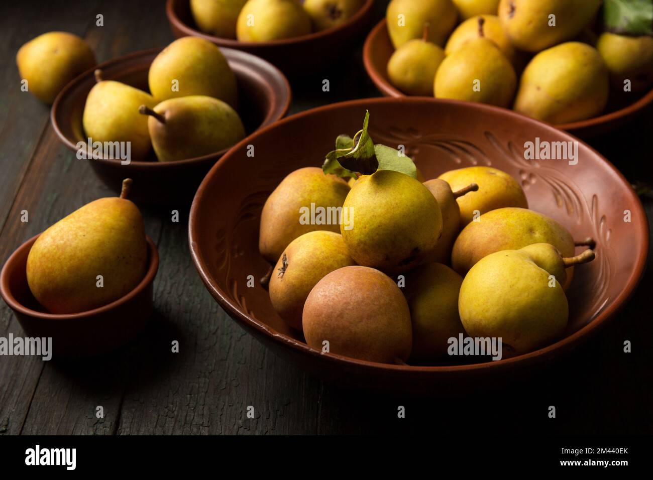 Delicious juicy homemade pears in clay plates on dark background in ...