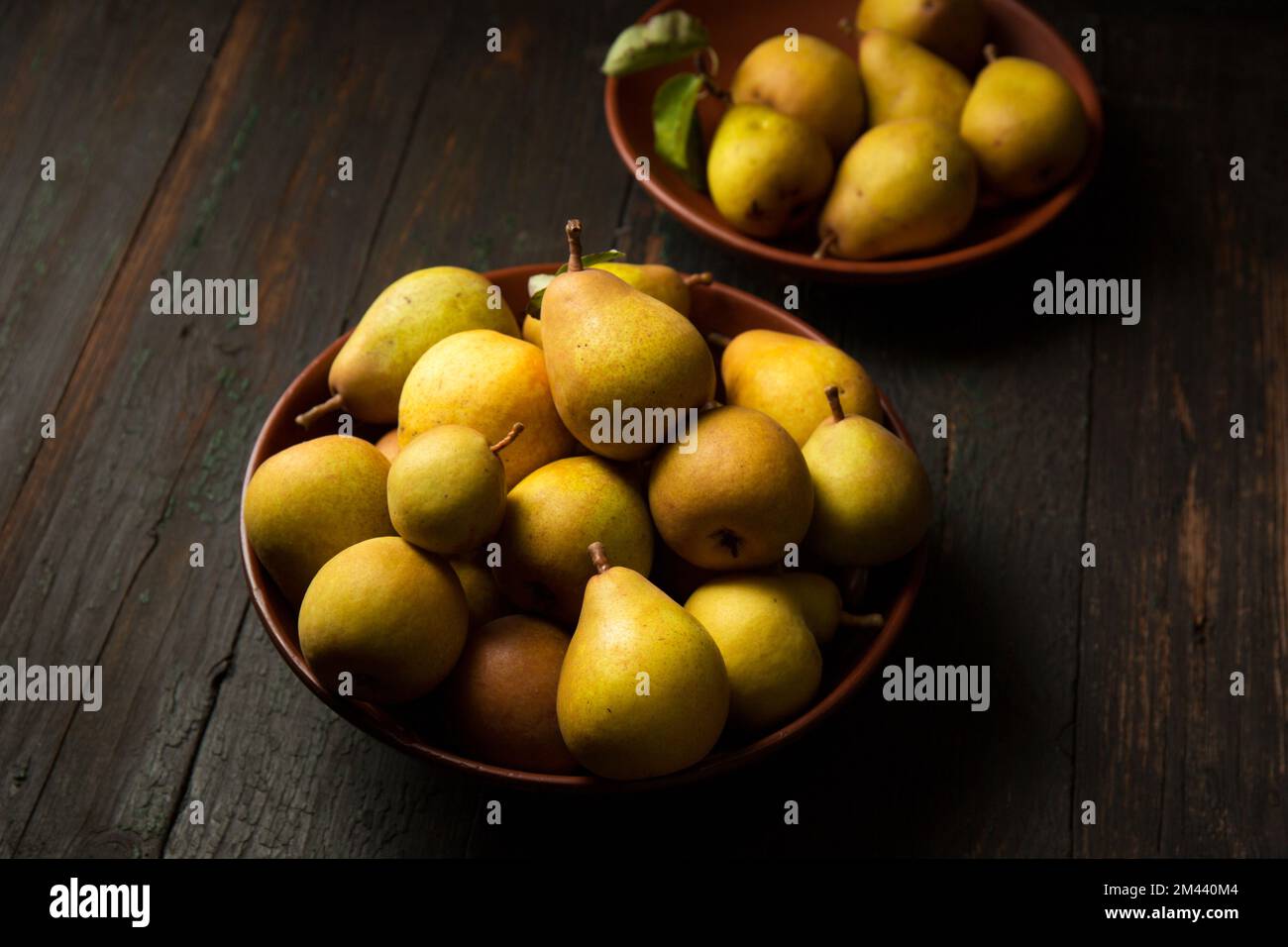 Delicious juicy homemade pears in clay plates on dark background in ...