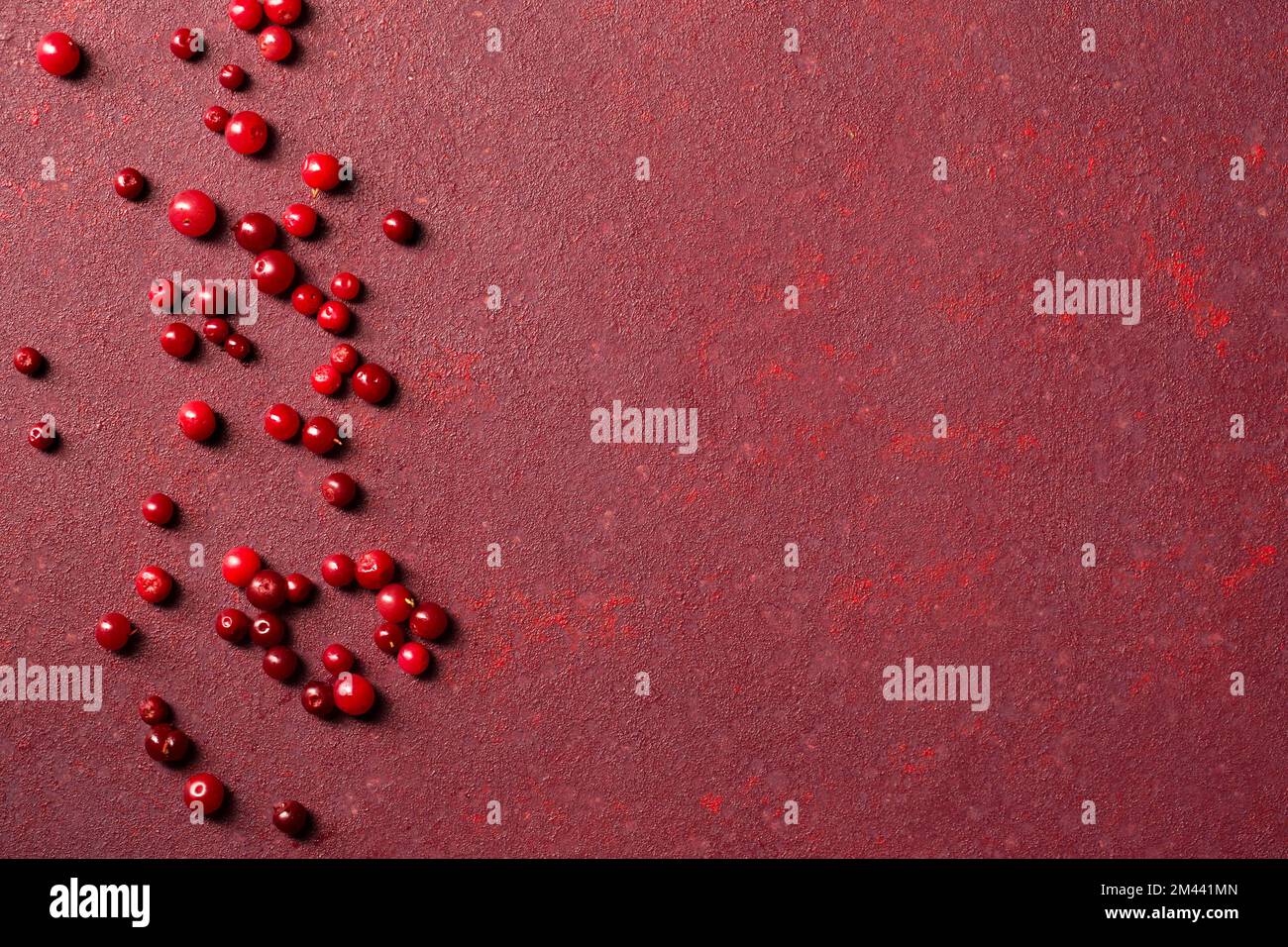 Delicious juicy lingonberry berry scattered on a burgundy background ...