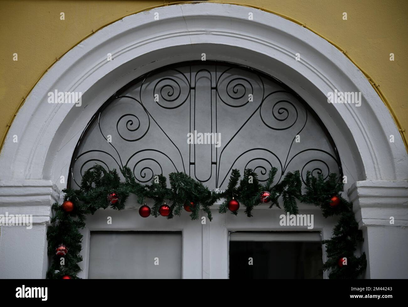 Old Neoclassical building arched entrance door with festive Christmas ...