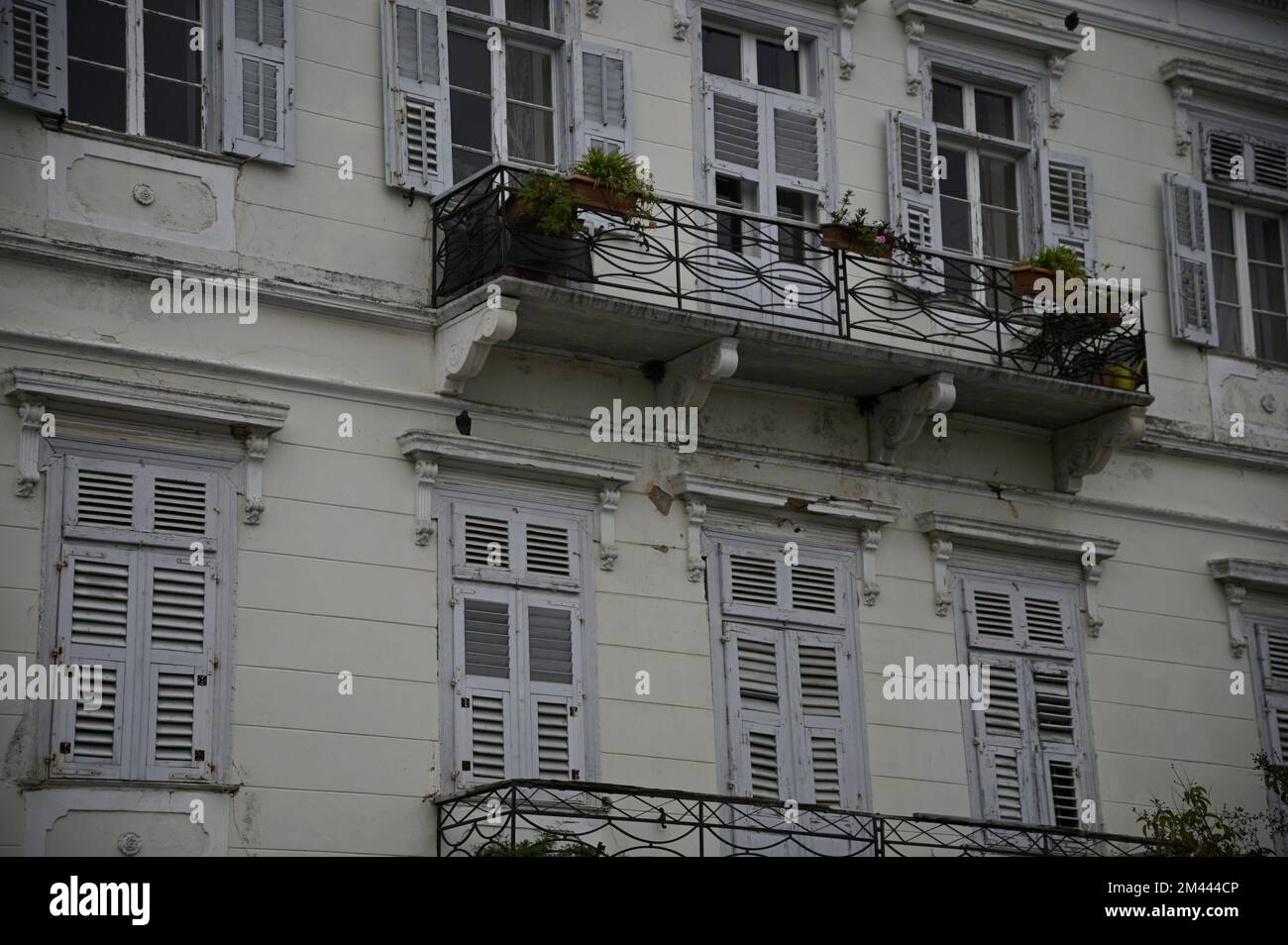 Neoclassical house facade with wooden window shutters and a balcony ...