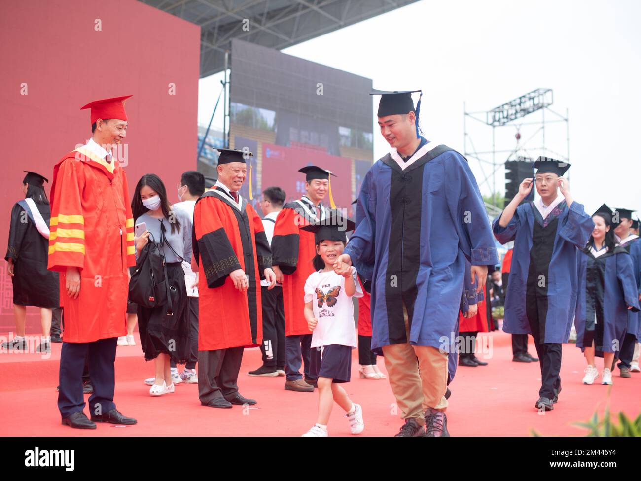 A post-graduate student with his daughter in the graduation ceremony ...