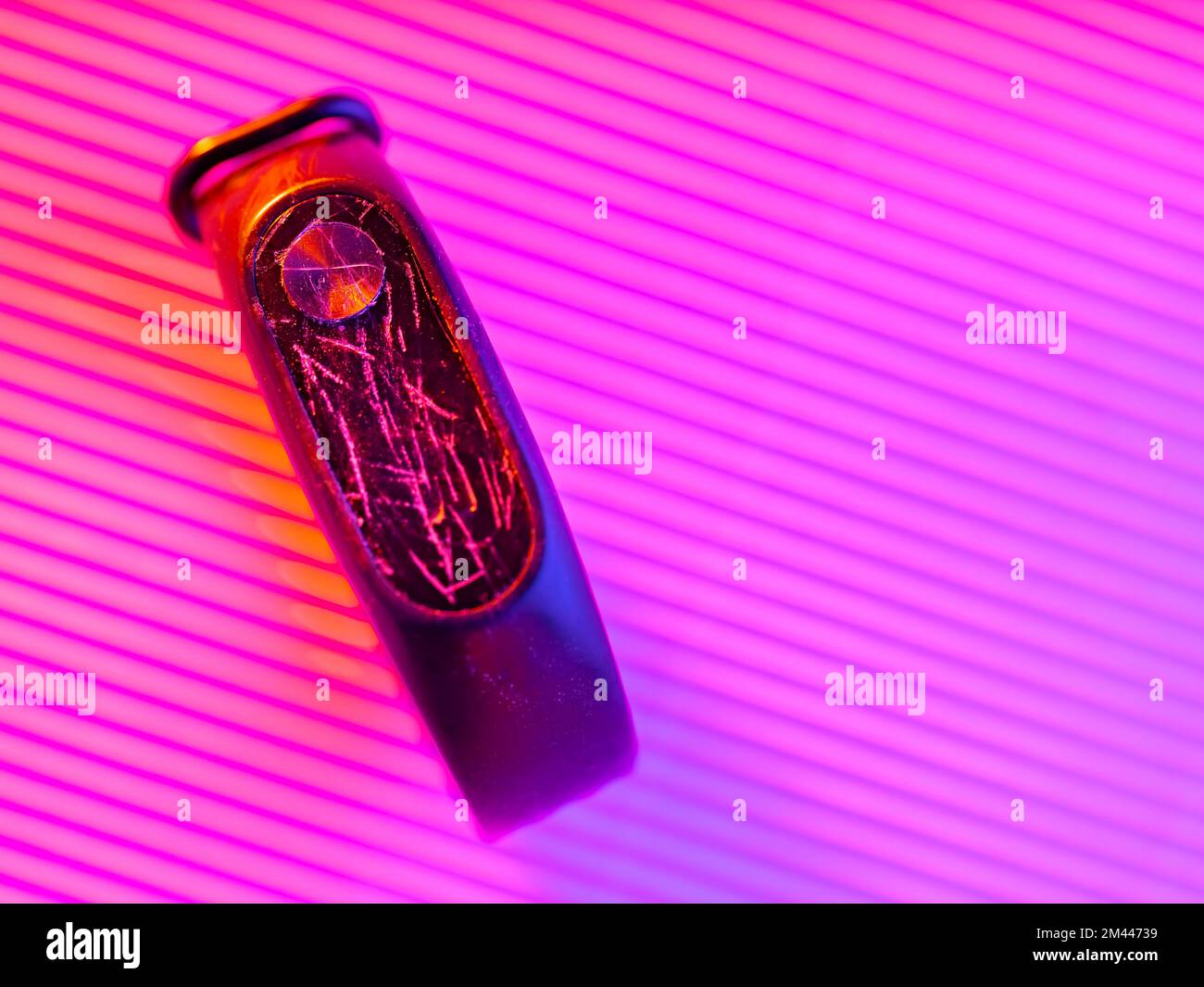 Fitness tracker with broken display in neon light. Smart watch with ...