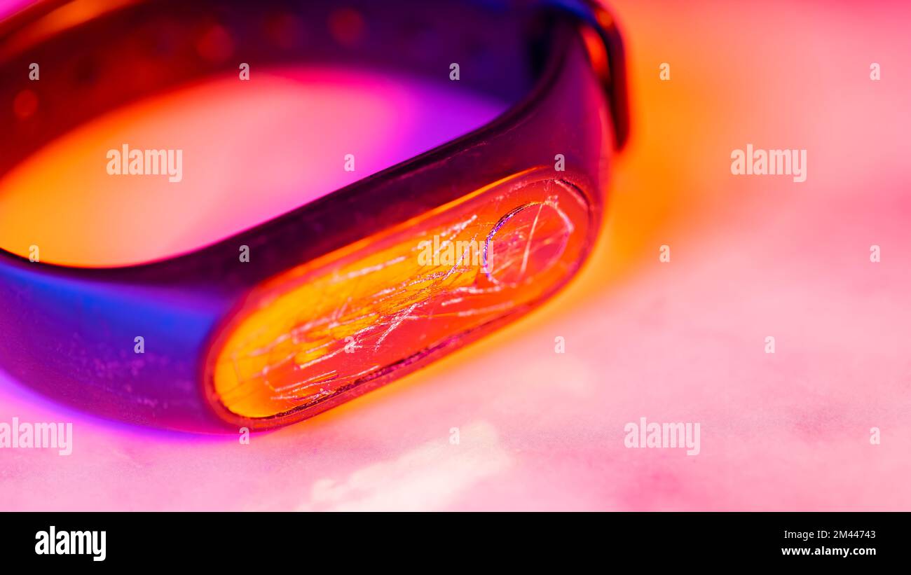 Fitness tracker with broken display in neon light. Smart watch with ...