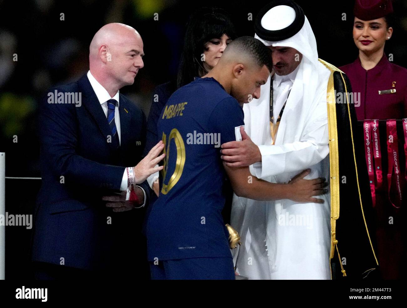 France's Kylian Mbappe is consoled by FIFA president Gianni Infantino ...