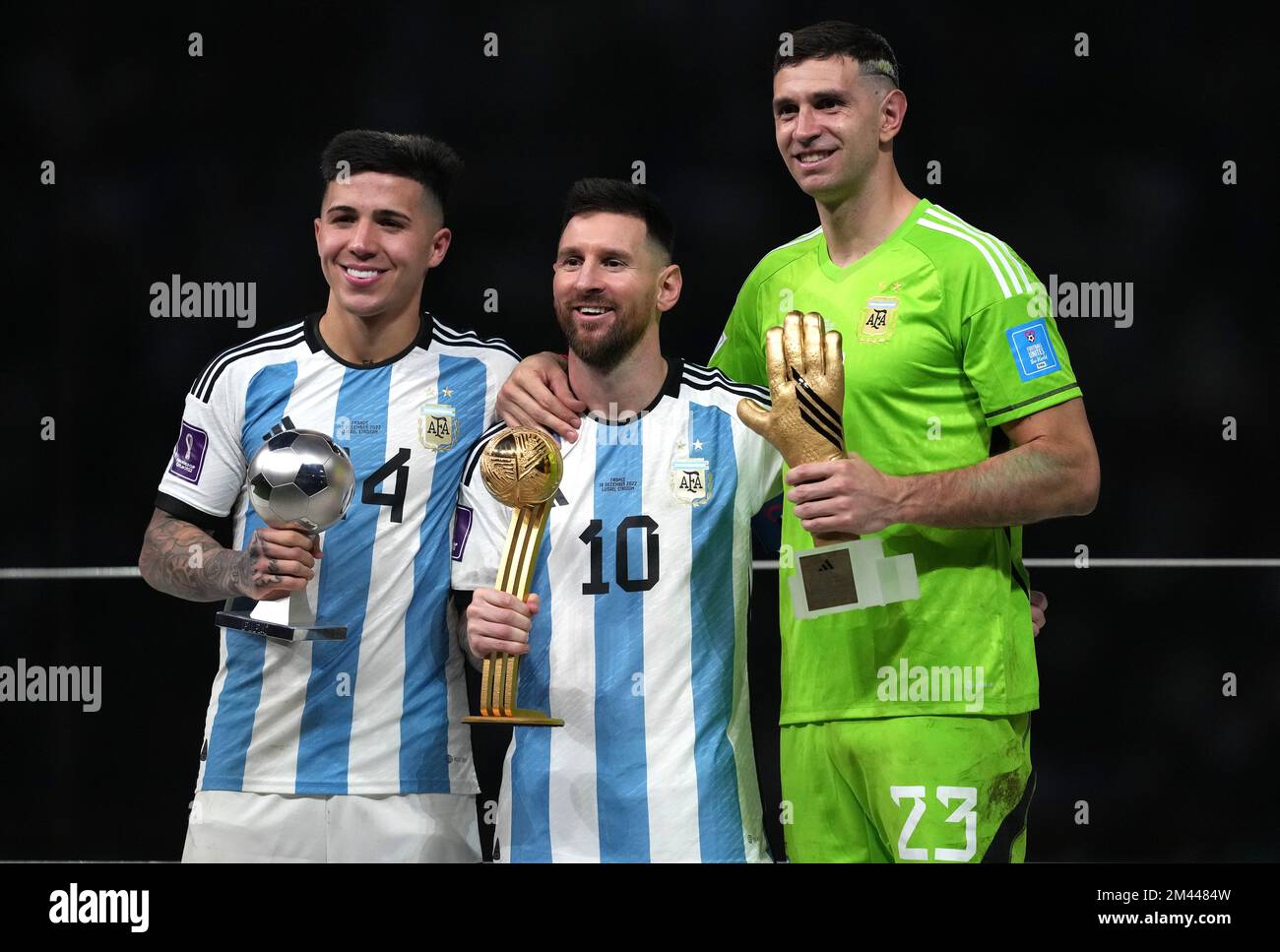 Argentina's Enzo Fernandez (left) with the Young Player Trophy, Lionel Messi with the Golden ...