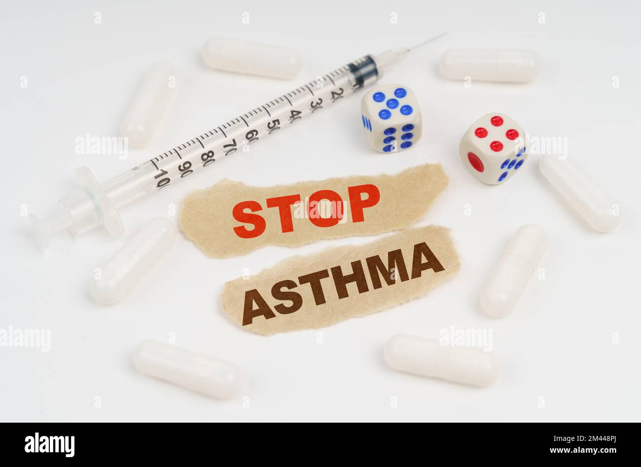 Medical concept. On a white surface lies a syringe, pills, dice and ...