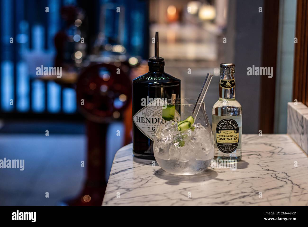 A closeup shot of a glass of Hendricks Gin Tonic with cucumber set on a ...