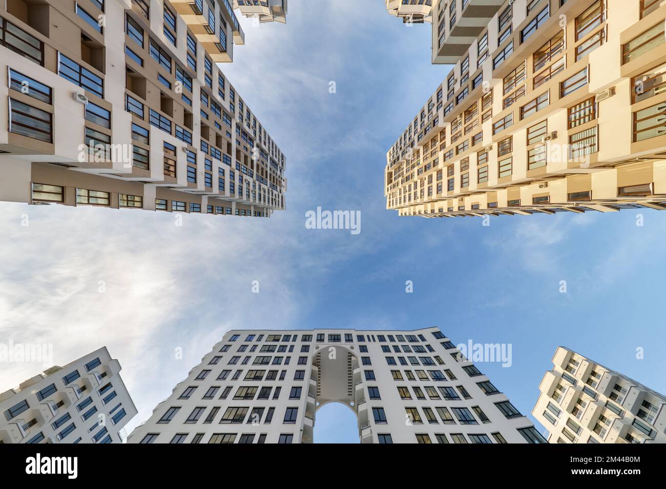view up from ground to blue sky among skyscrapers, look at house from ...
