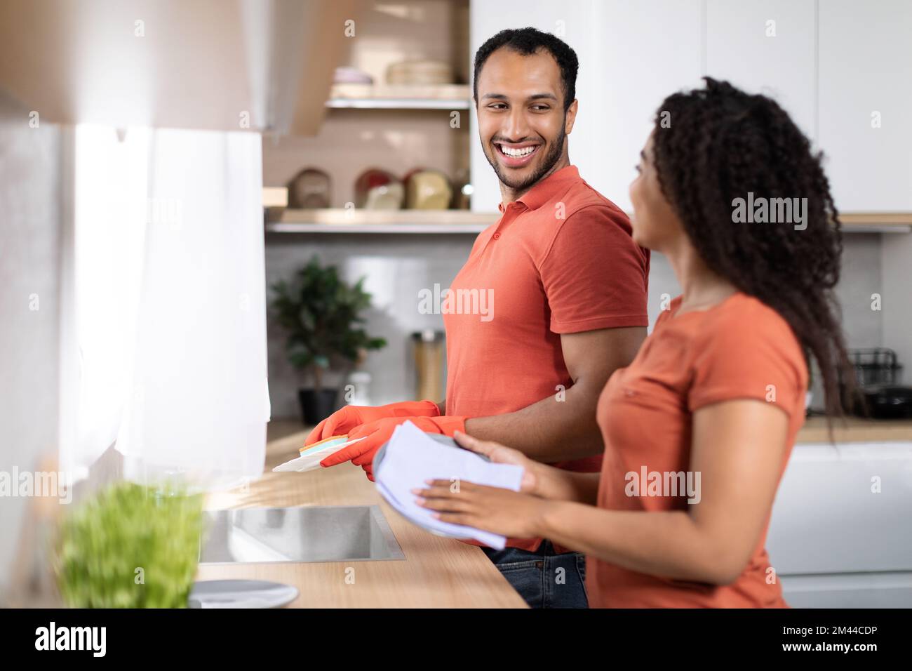 Cleaning and household chores at home. Cheerful black millennial wife ...