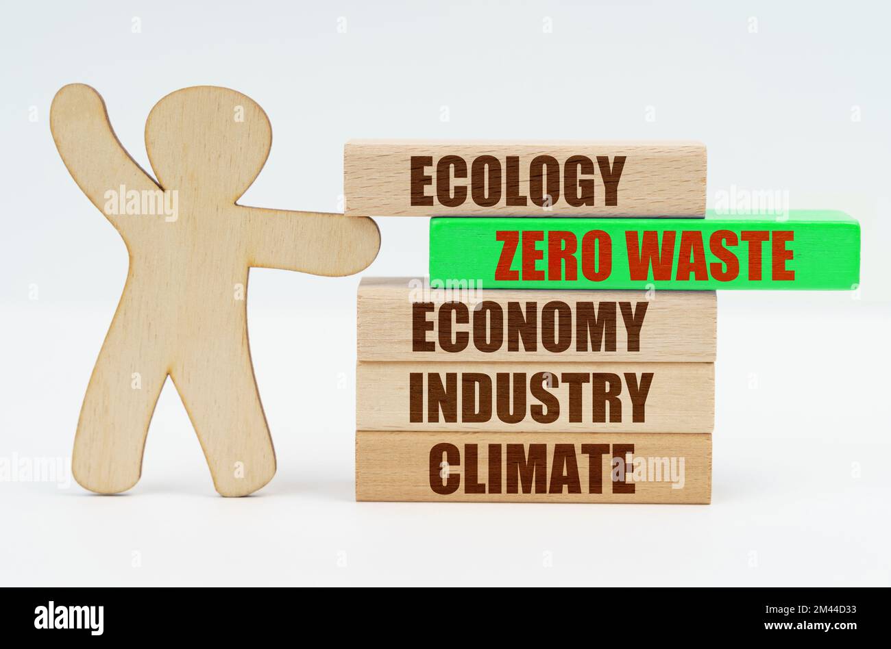 Ecology and industry concept. The wooden man moves the green block with ...