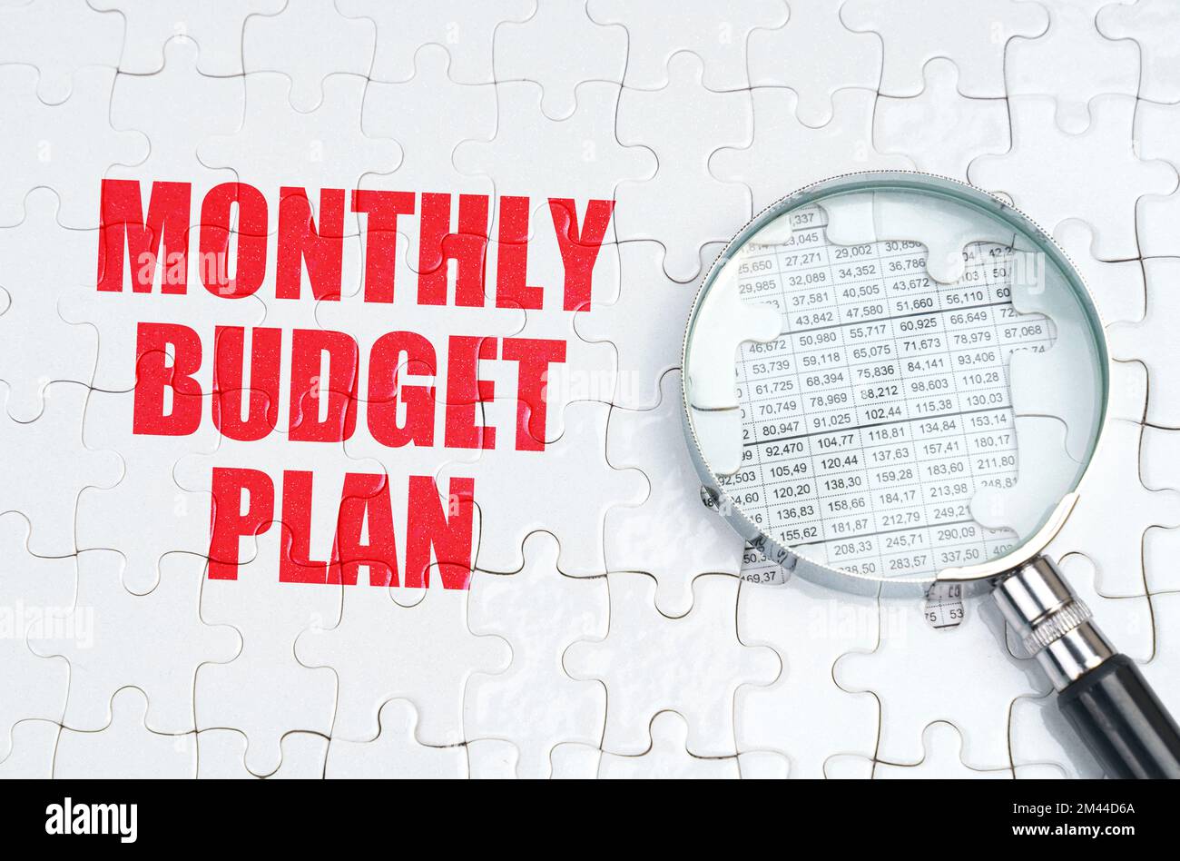 Business concept. There is a magnifying glass on the puzzles, next to ...