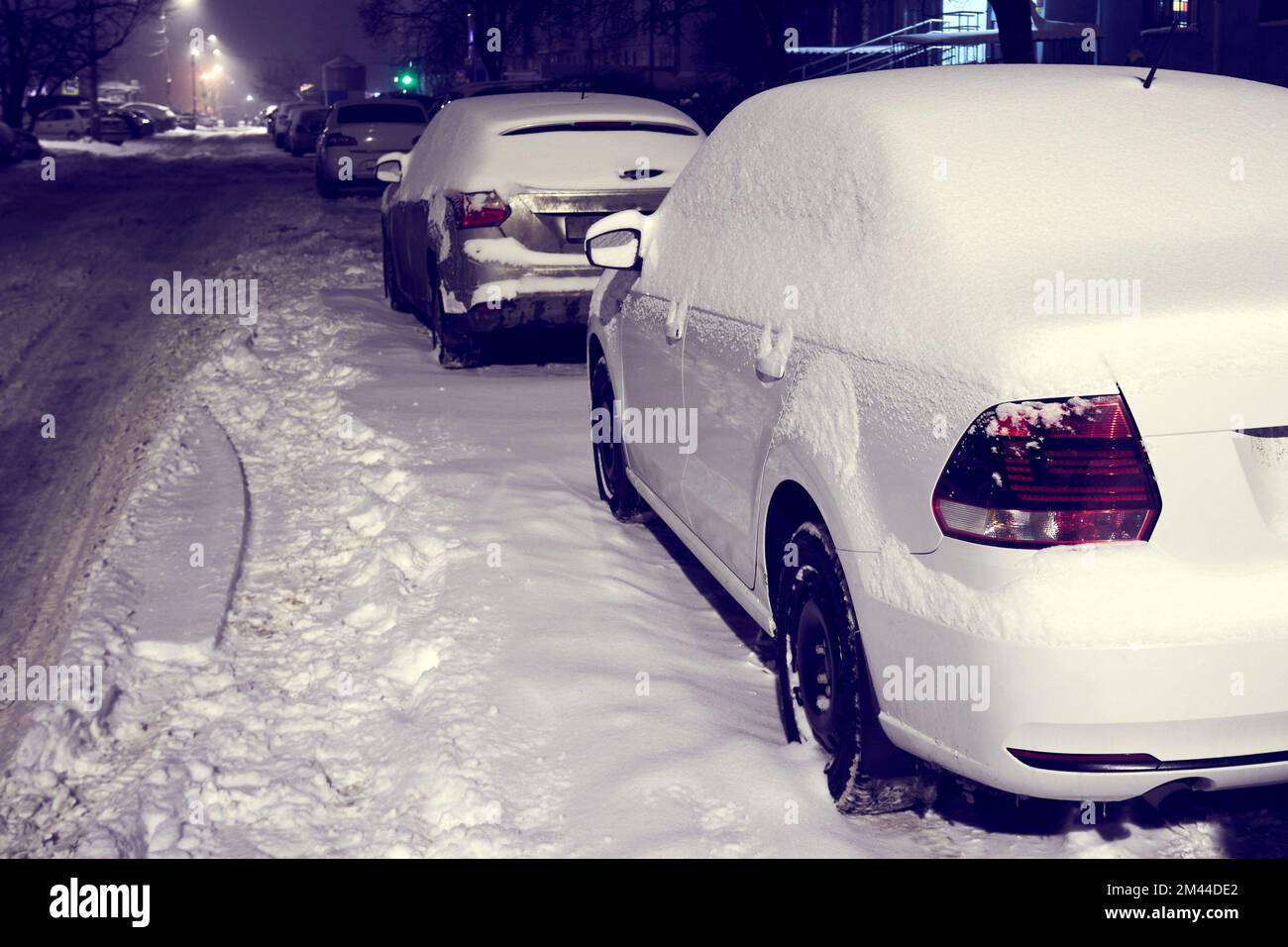 Cars covered with snow on a city street at night Stock Photo - Alamy