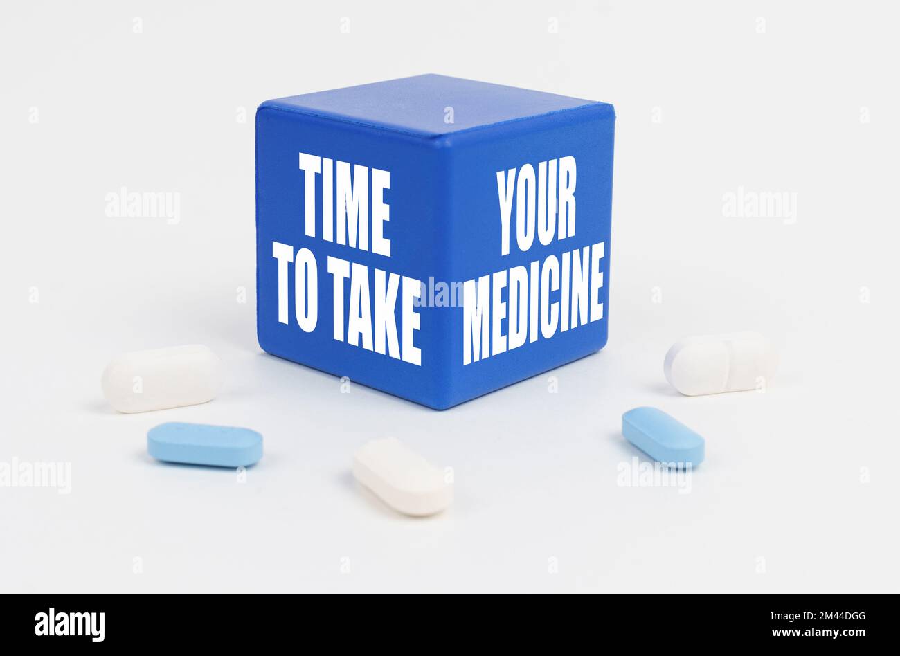 Medicine and health concept. On a white surface are pills and a blue ...