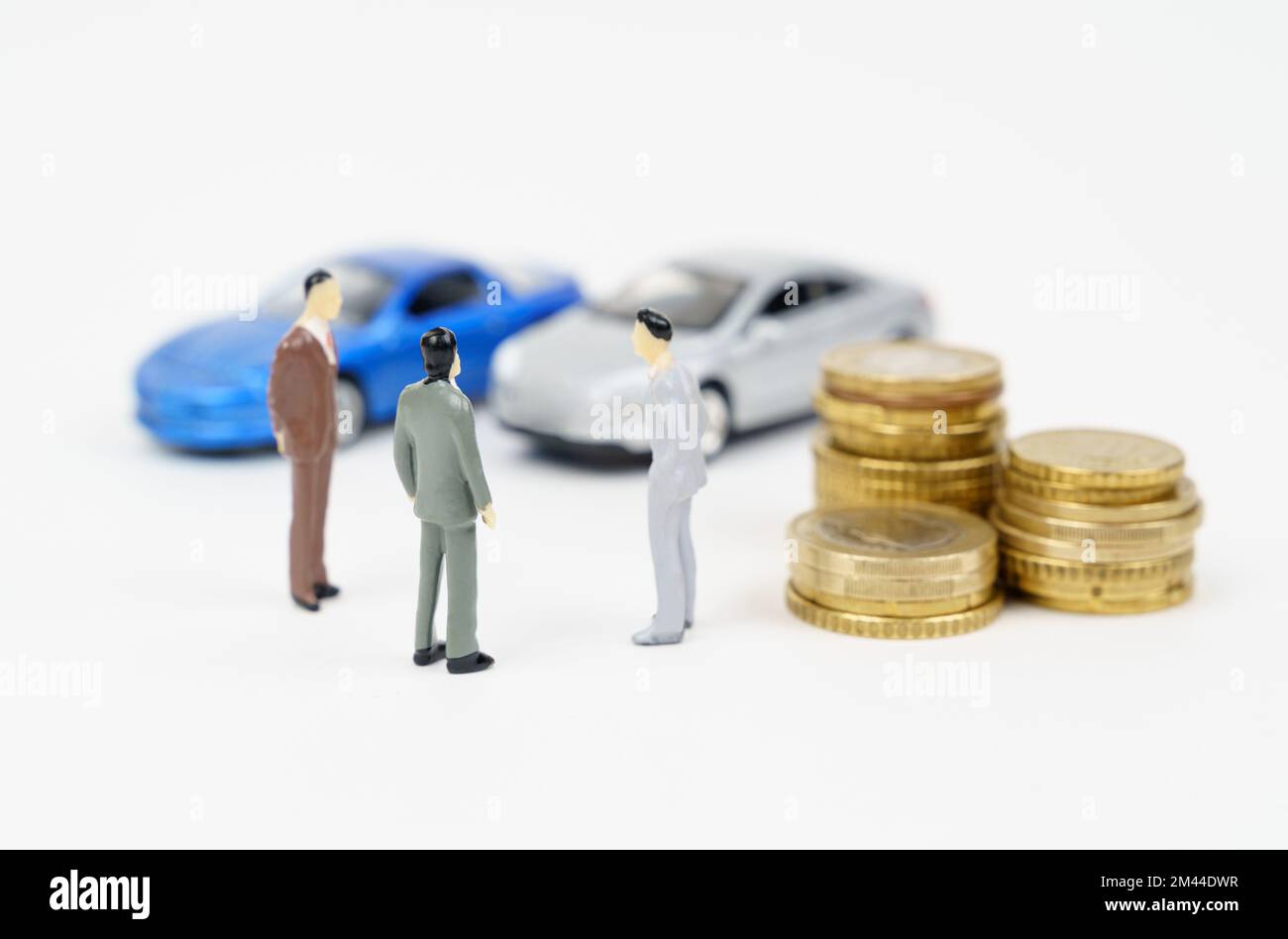Car business, car sales, deal. On the white surface are cars, coins and ...