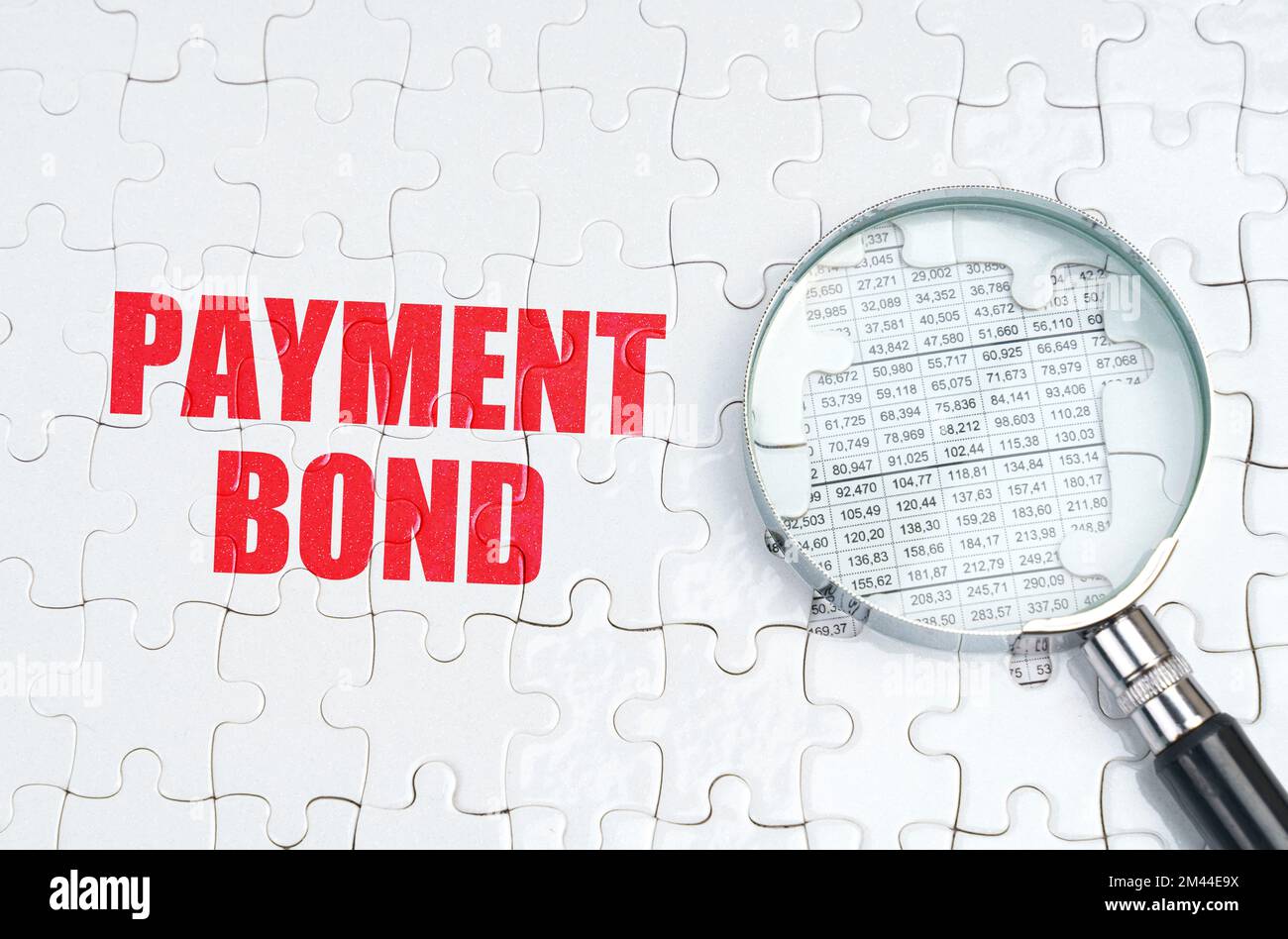 Business concept. There is a magnifying glass on the puzzles, next to ...