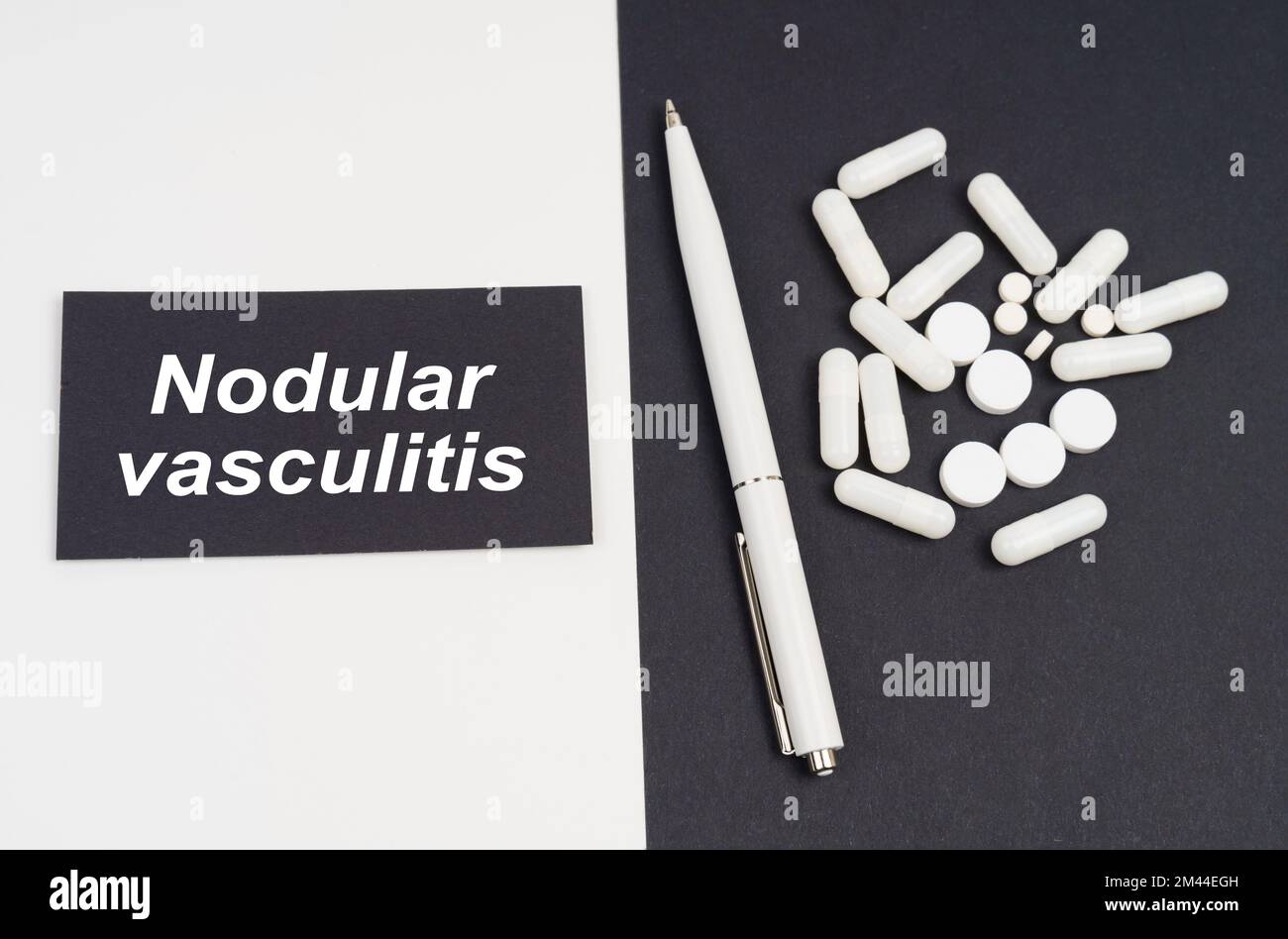 Medical concept. On a white and black surface are pills, a pen and a ...
