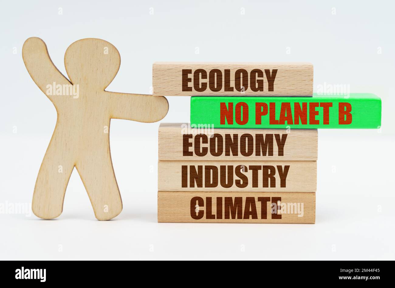 Ecology and industry concept. The wooden man moves the green block with ...