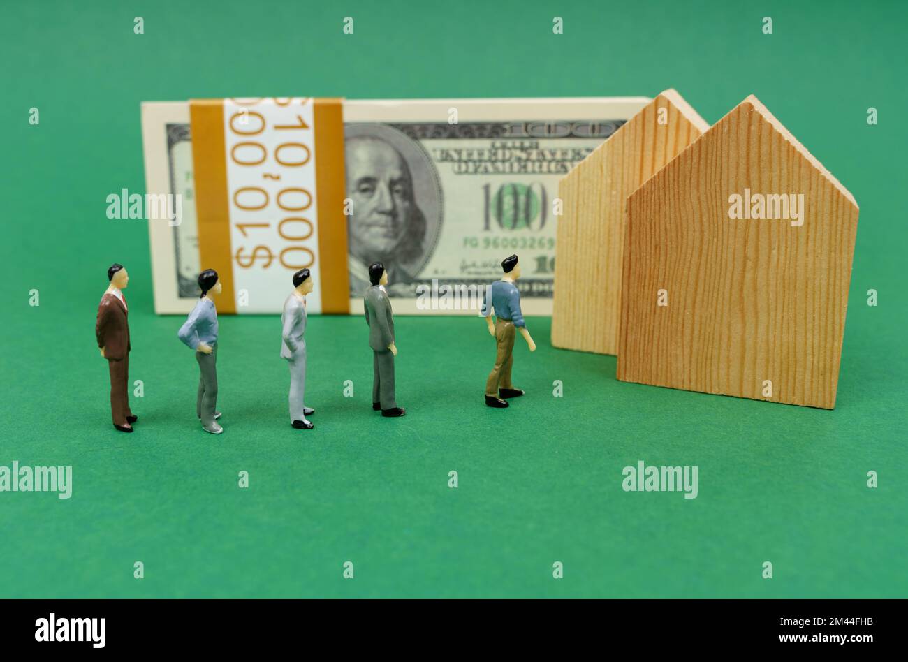 Economic concept. On the green surface are wooden houses, a stack of ...