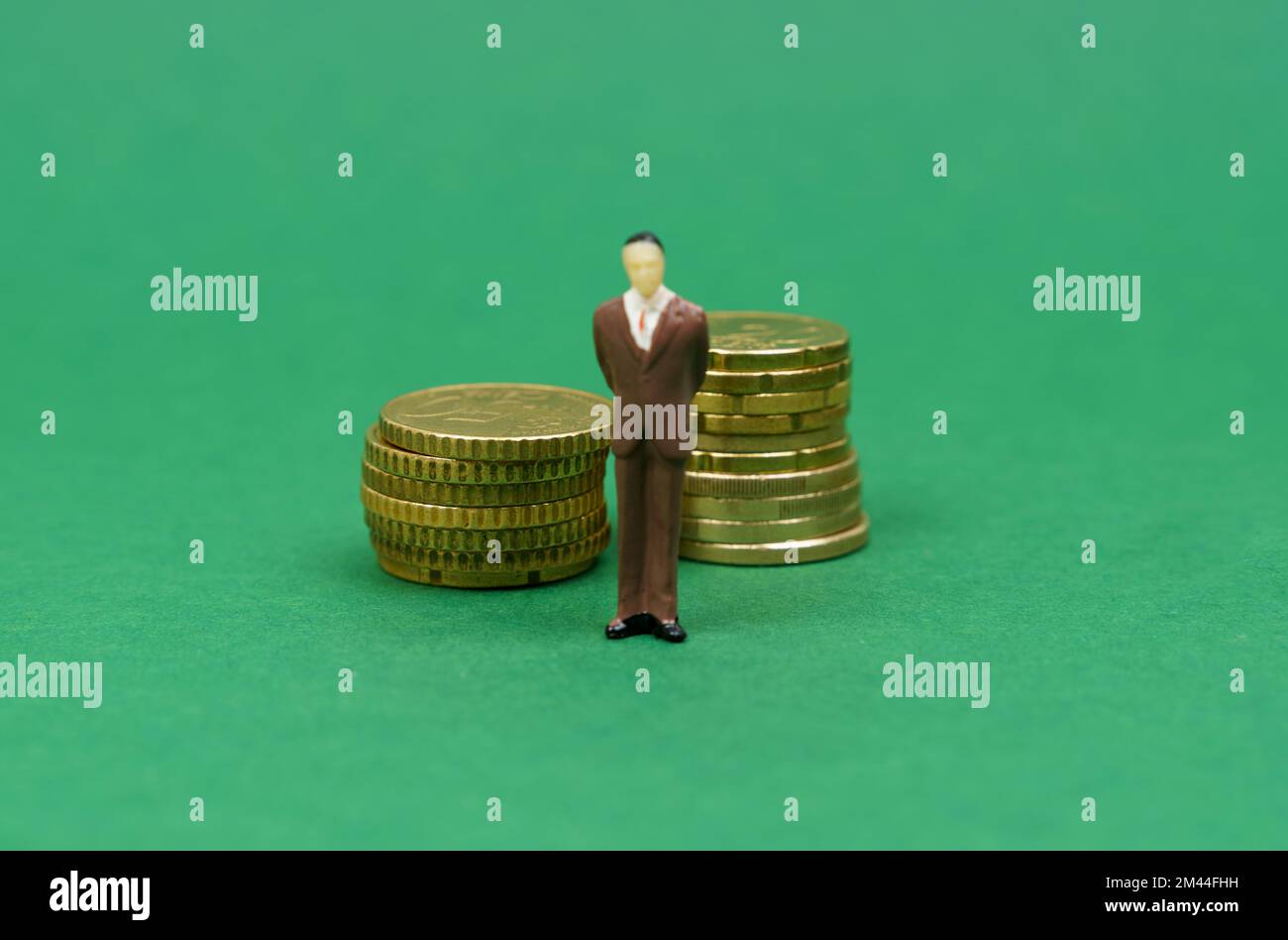 Economic concept. Miniatures. On the green surface are coins and a ...