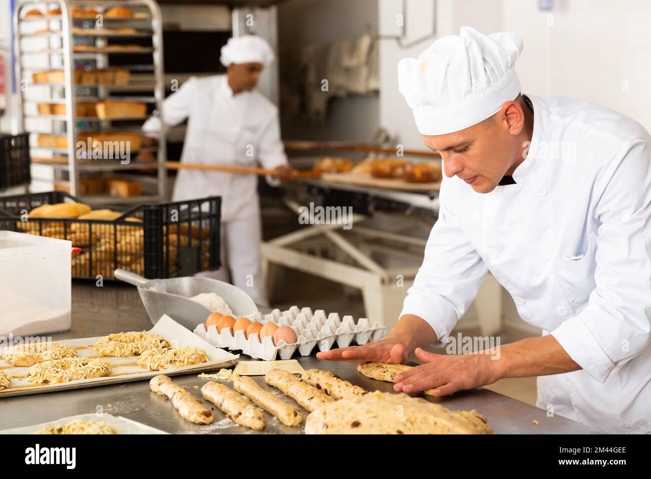 Concentrated baker preparing sweet buns in bakery Stock Photo - Alamy