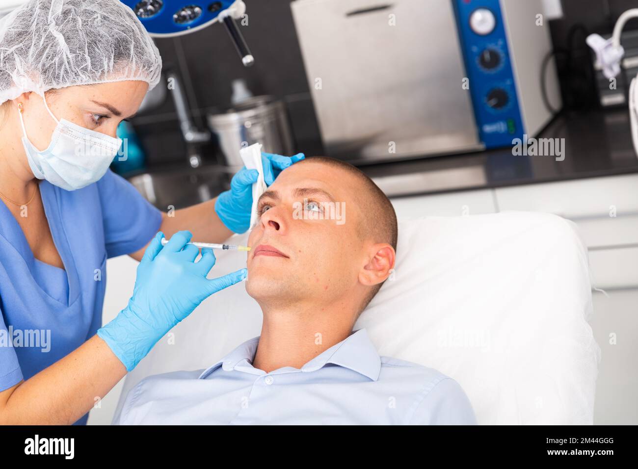 Man receiving facial contouring injections in cosmetology clinic Stock ...