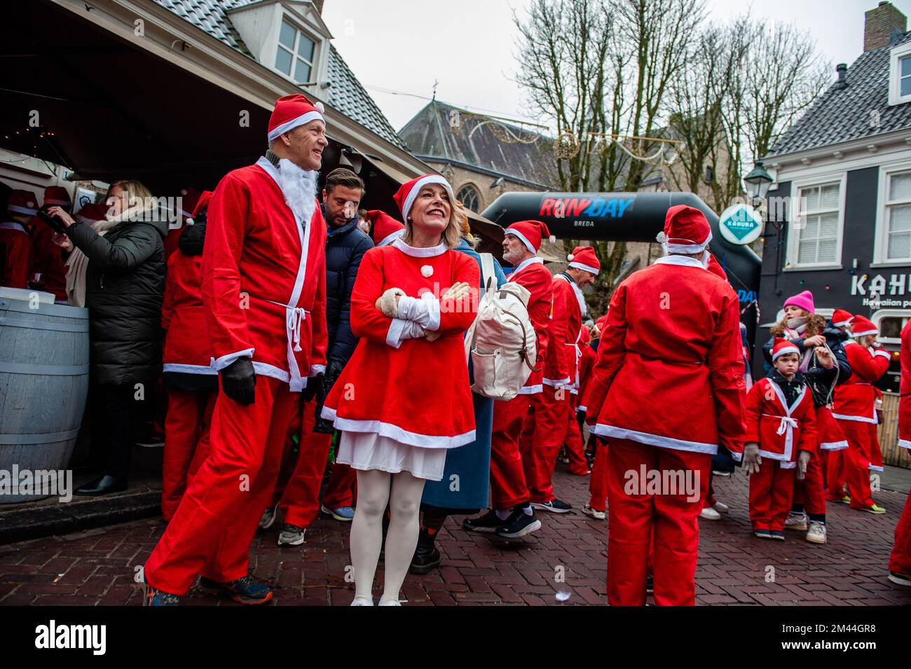 People wearing Santa costumes are seen waiting on the street on a very ...