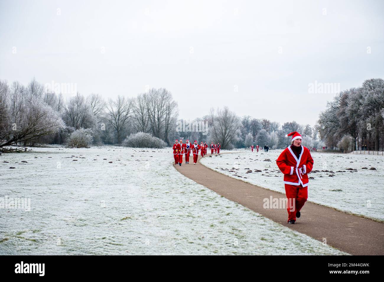 A view of a white landscape with people running wearing Santa costumes ...