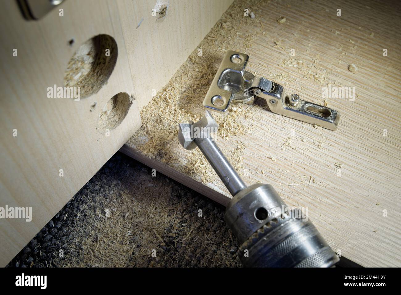 Hinge fixed on a modern cabinet. Tools for installation furniture ...