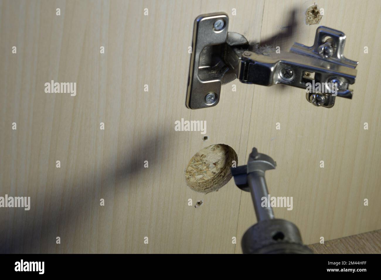 Repair furniture fittings. hinge fixed on a cabinet Stock Photo - Alamy